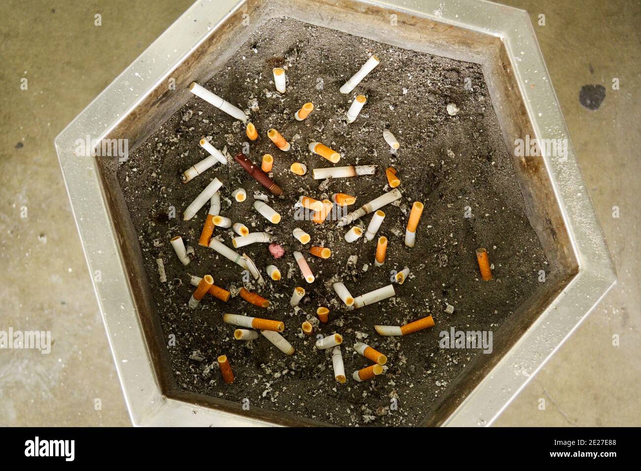 Used cigarettes filters in ashtray. Cigarette butt in dirty trash box ...