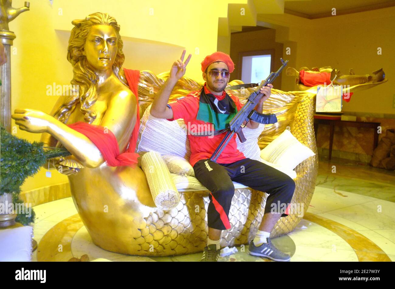 A young Libyan rebel sits on the 'golden mermaid' couch, on which Aisha ...