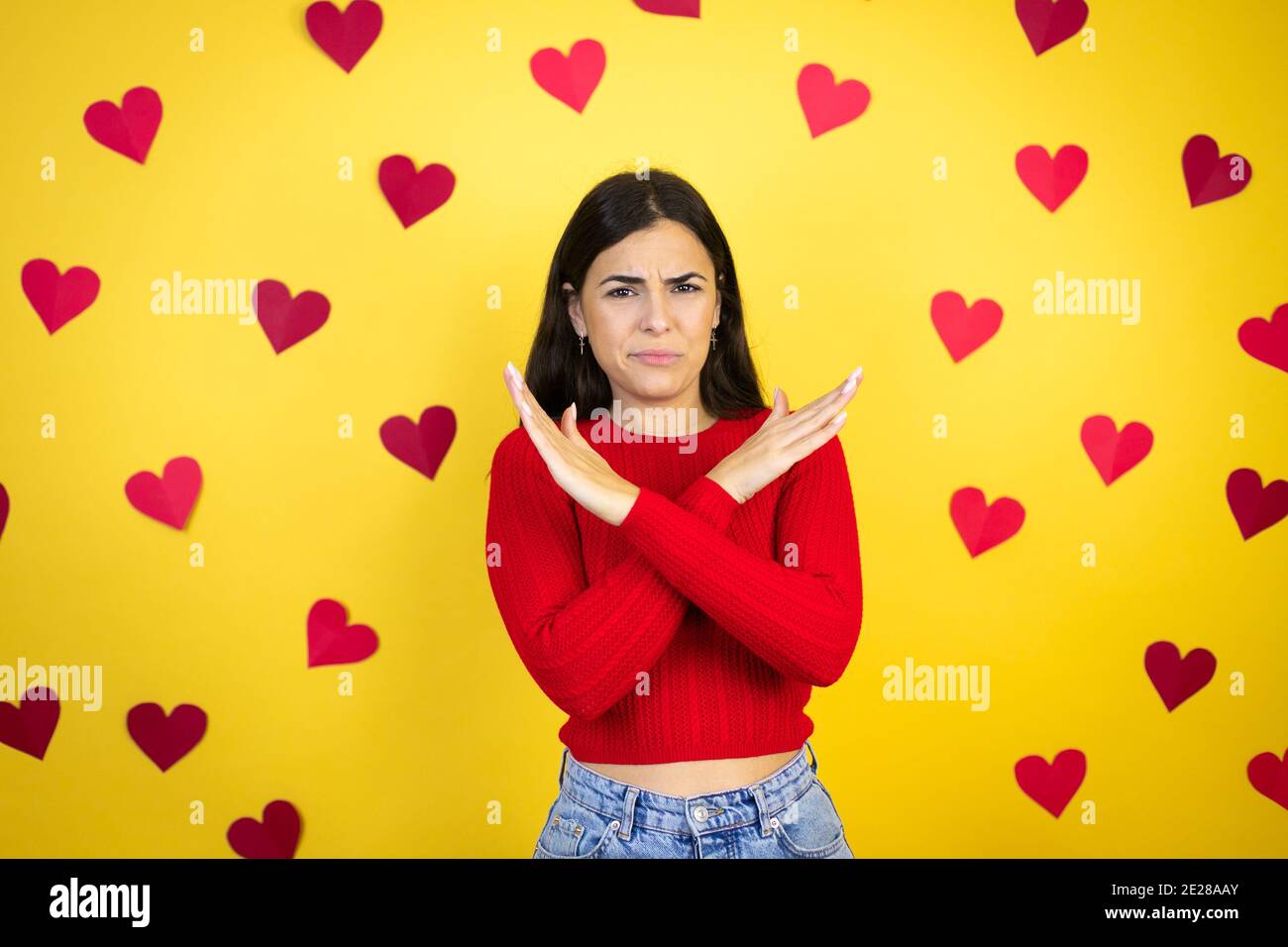 Young caucasian woman over yellow background with red hearts Rejection ...