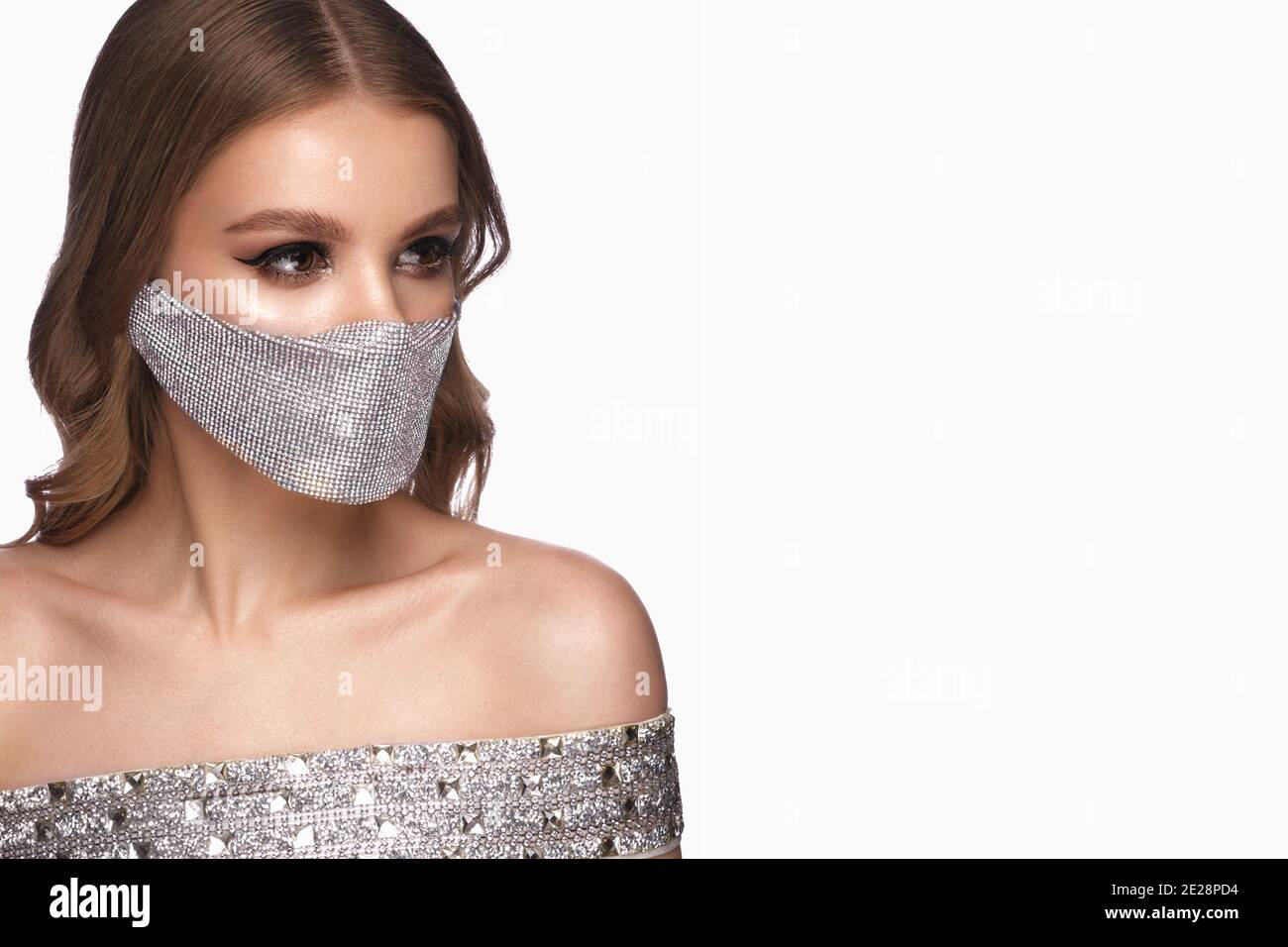 Portrait of a beautiful woman in a silver mask with rhinestones and ...