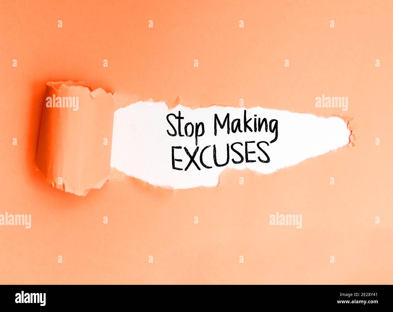 Motivational phrase Stop Making Excuses, written on a torn paper ...