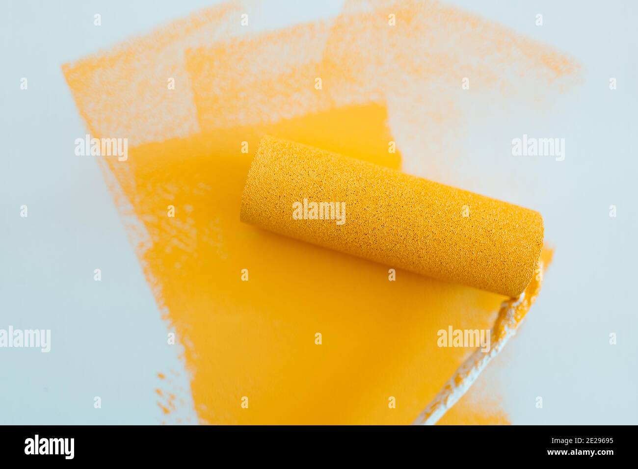 Painting roll with yellow paint over white background Stock Photo - Alamy