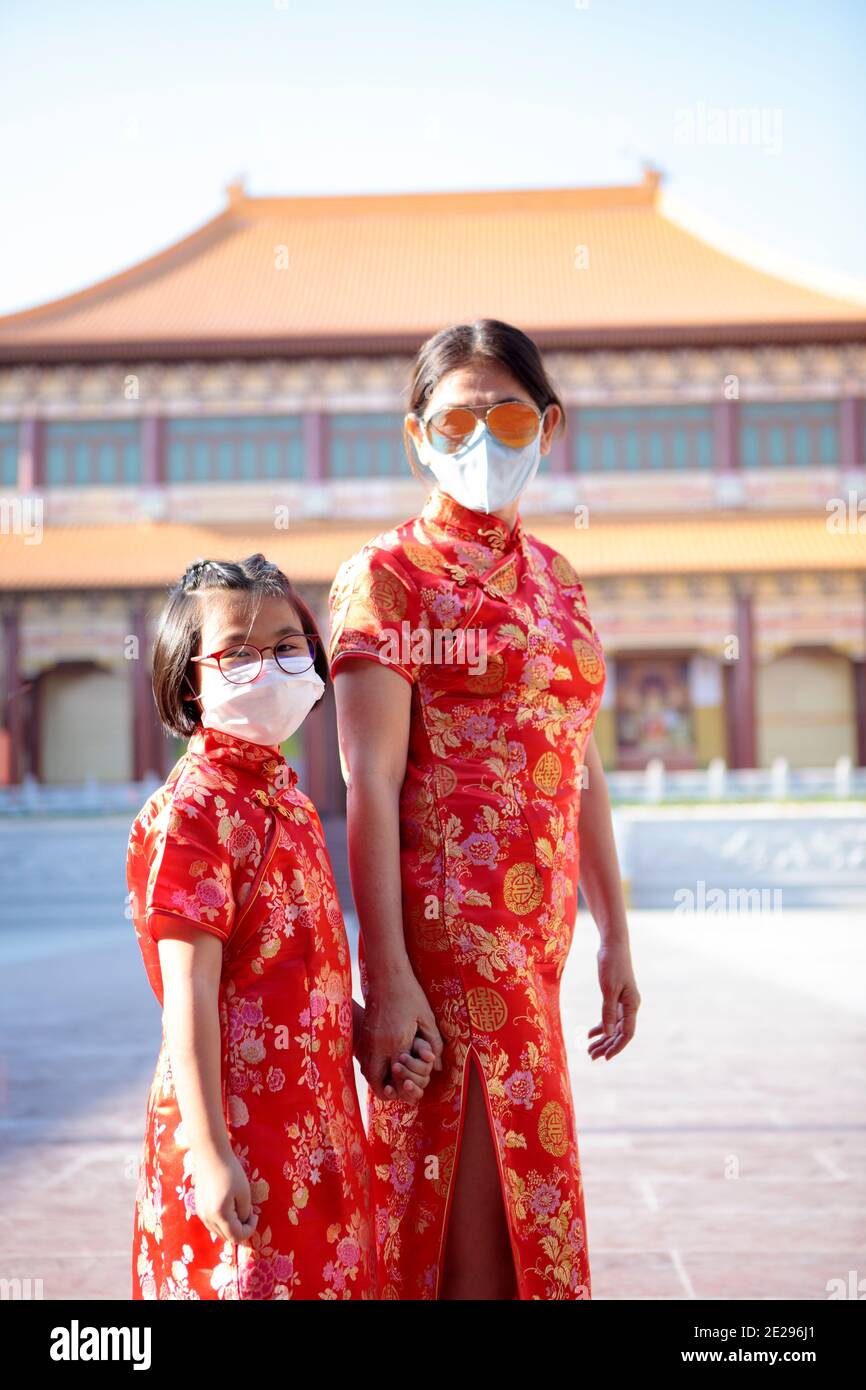asian woman and girl wearing red chinese suit and wearing face ...
