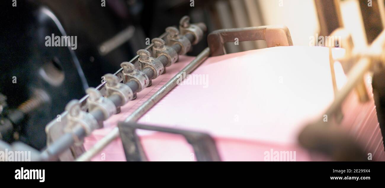 The photo effect with the printing press machine takes sheet of paper ...