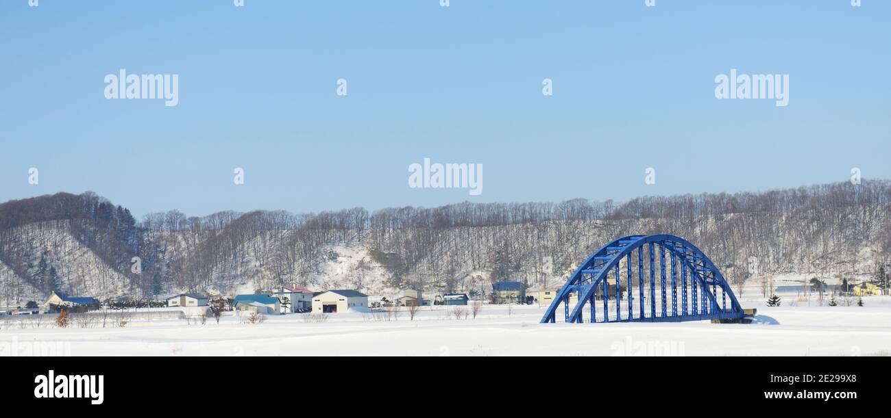 A blue bridge in the snowy landscapes of Hokkaido, Japan Stock Photo ...