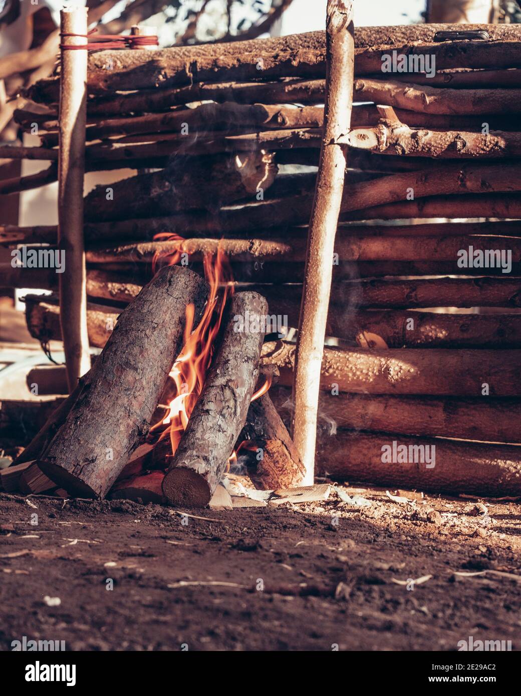 Vertical shot of burning logs protected with wooden fence in the ...