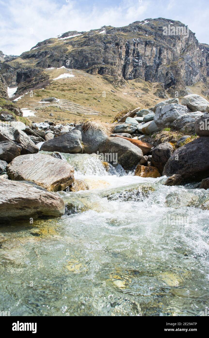 Vertical shot of a river flowing in the middle of the hills captured in ...