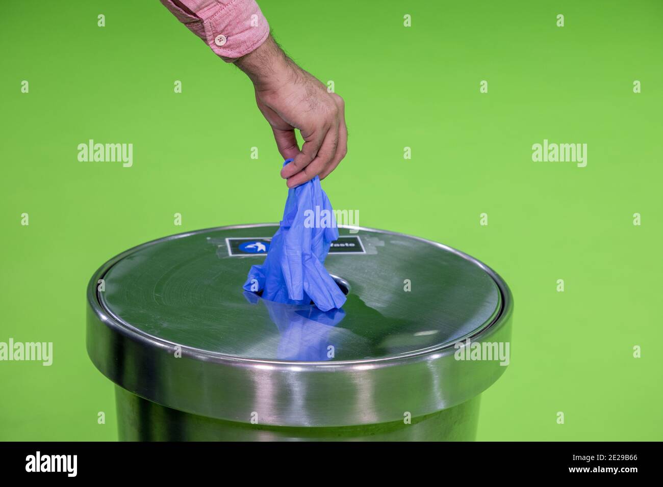 hands remove glove on green background and dump into trash can Stock ...