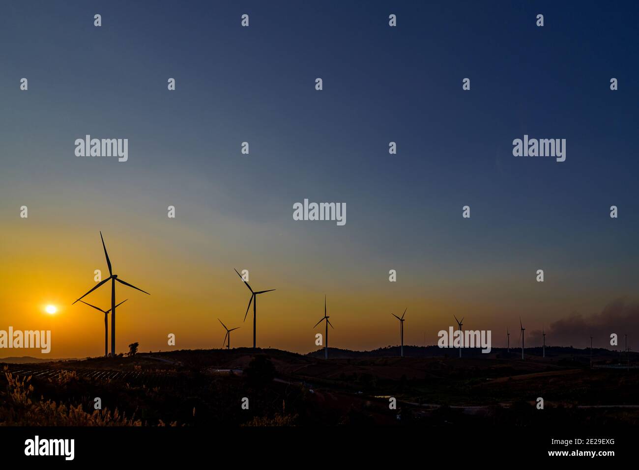 Wind turbine farm over sunset sky Generating Electricity. Renewable ...
