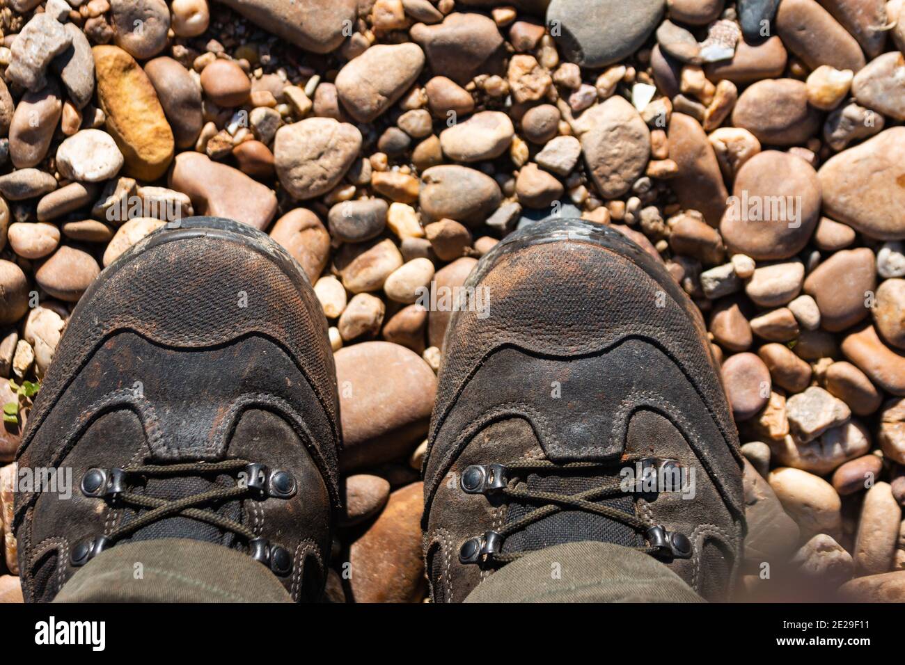 Top view of man feet with boots standing on pebbles at sunlight Stock ...