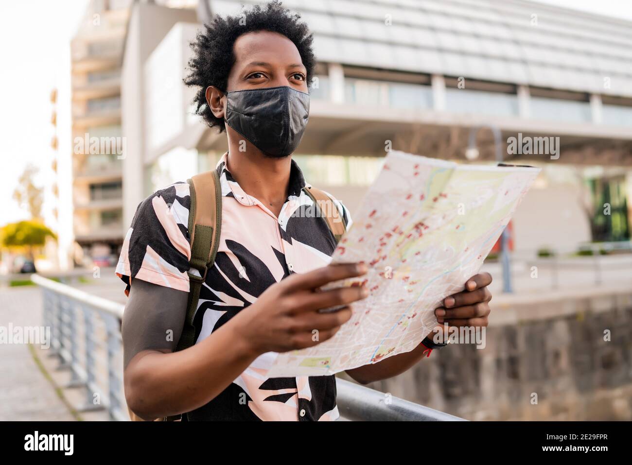 Tourist man looking for directions on map Stock Photo - Alamy