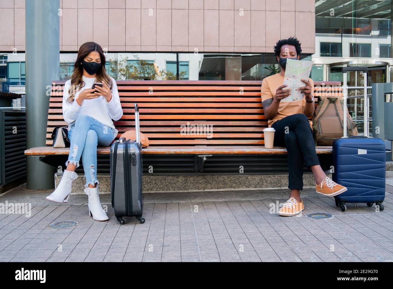 Tourist people waiting outside airport or train station Stock Photo - Alamy