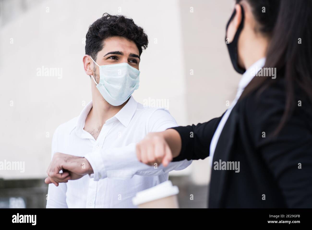 Business people bumping elbows for greeting each other Stock Photo - Alamy