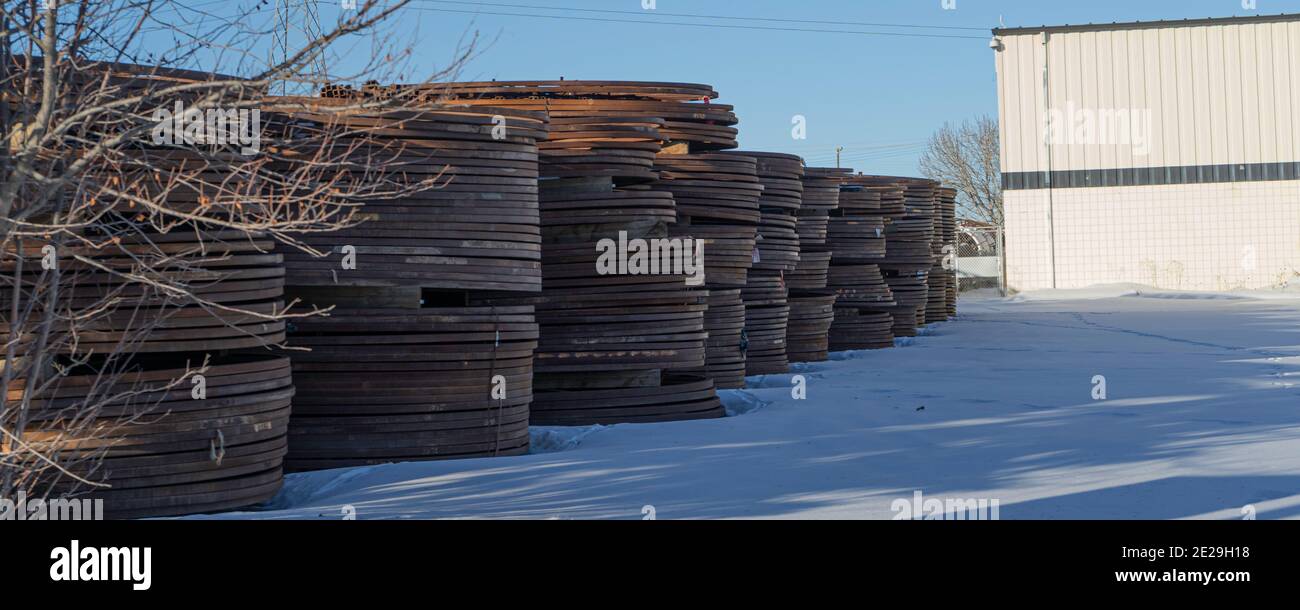 Stack of metal coils stored outside for manufacturing Stock Photo - Alamy