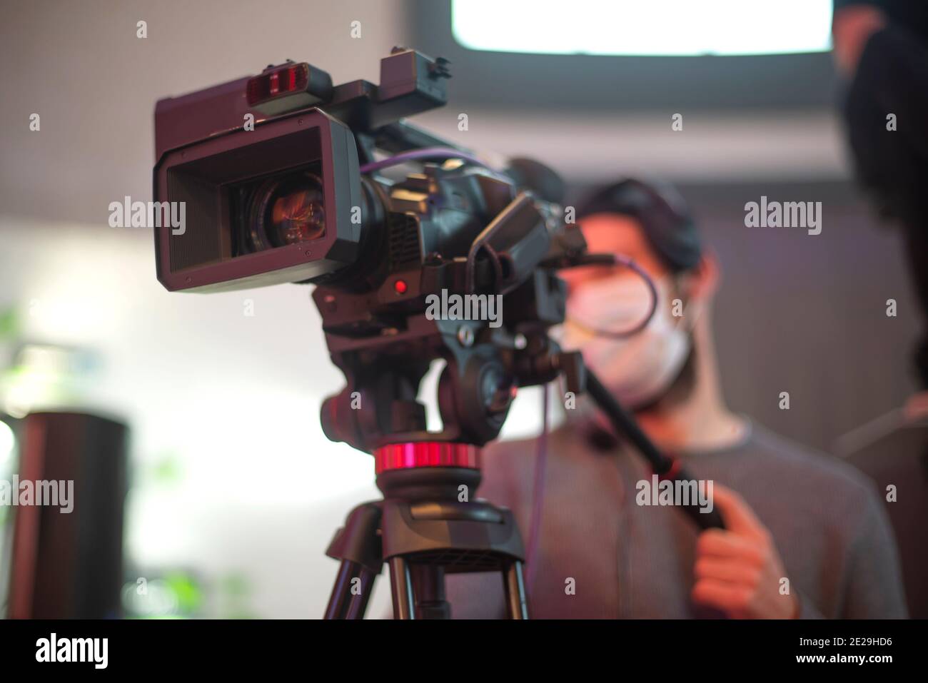 masked cameraman is filming a television show in the studio. TV Stock ...