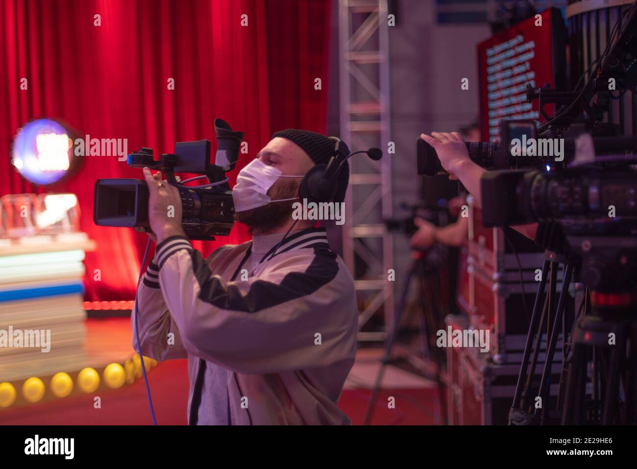 masked cameraman is filming a television show in the studio. TV Stock ...