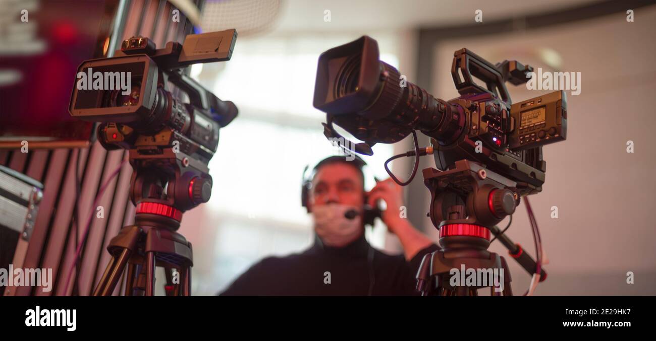 masked cameraman is filming a television show in the studio. TV Stock ...