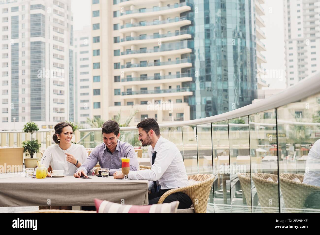 Business meeting on modern balcony in Dubai Marine . Three people ...