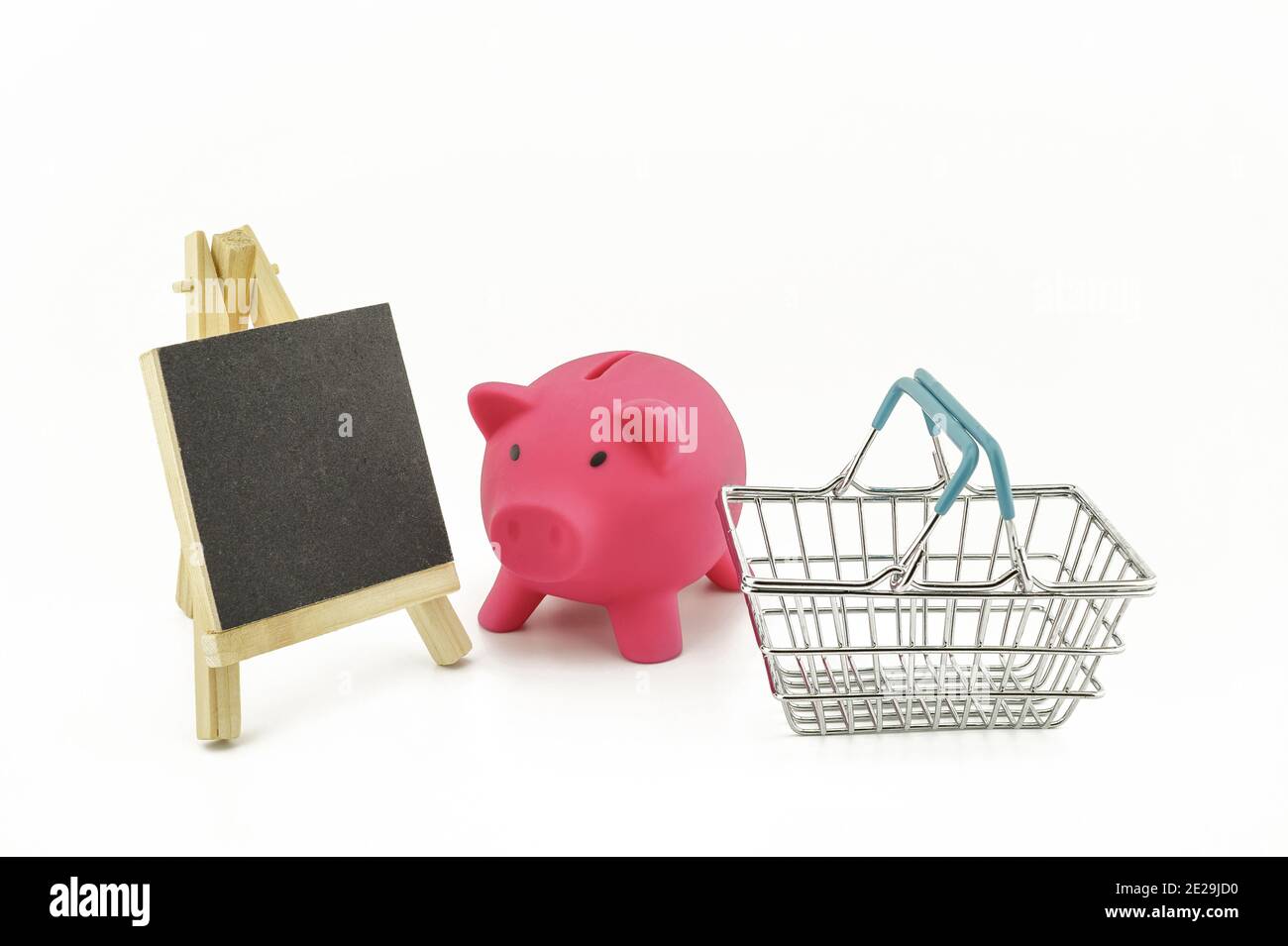 Pink pig saver, small chalk board and wire shopping basket isolated on ...