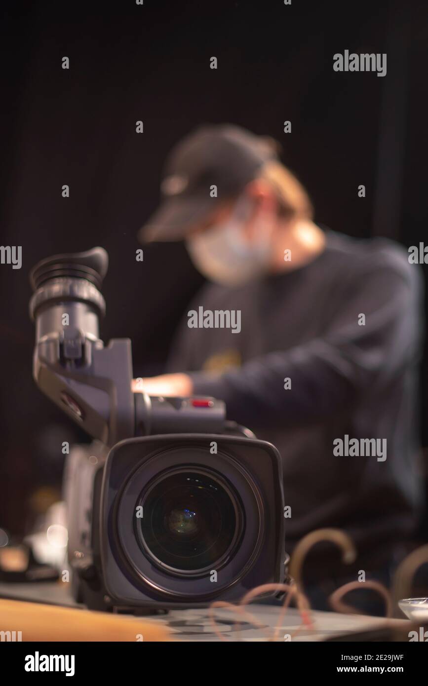 masked cameraman is filming a television show in the studio. TV Stock ...