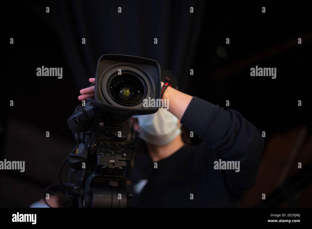 masked cameraman is filming a television show in the studio. TV Stock ...