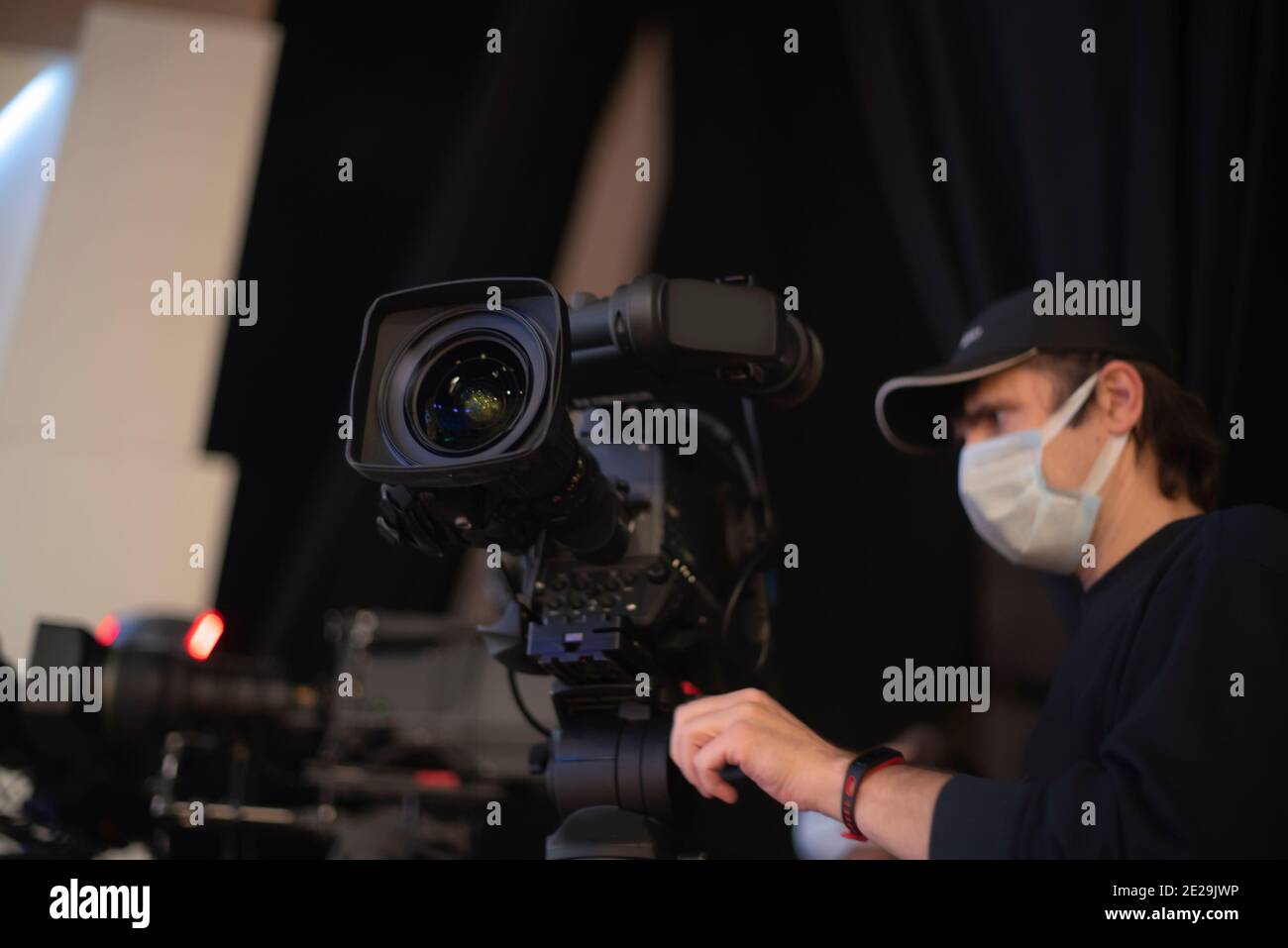 masked cameraman is filming a television show in the studio. TV Stock ...