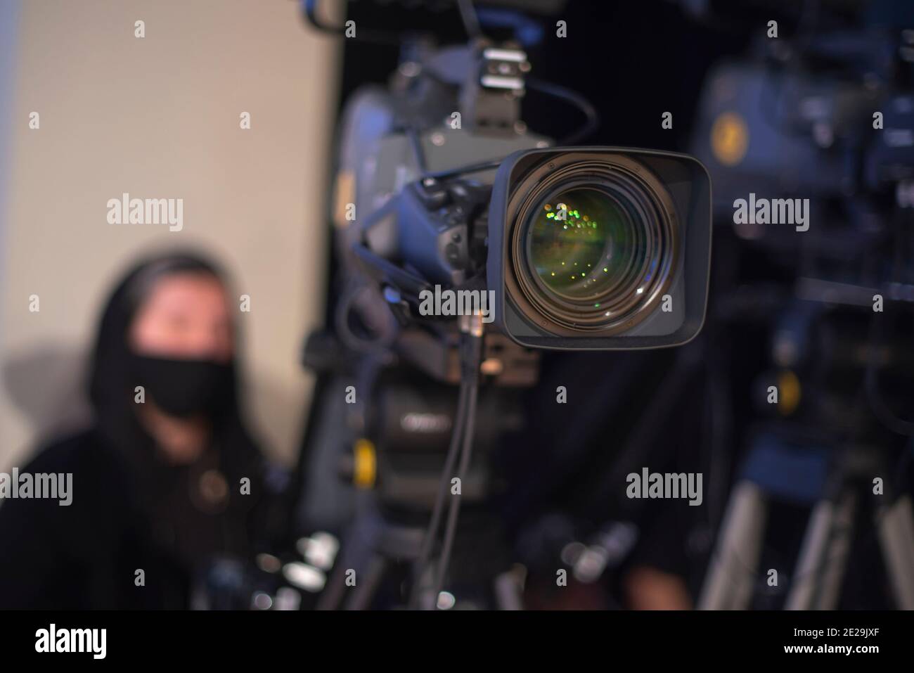 masked cameraman is filming a television show in the studio. TV Stock ...