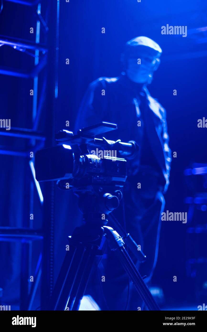 masked cameraman is filming a television show in the studio. TV Stock ...