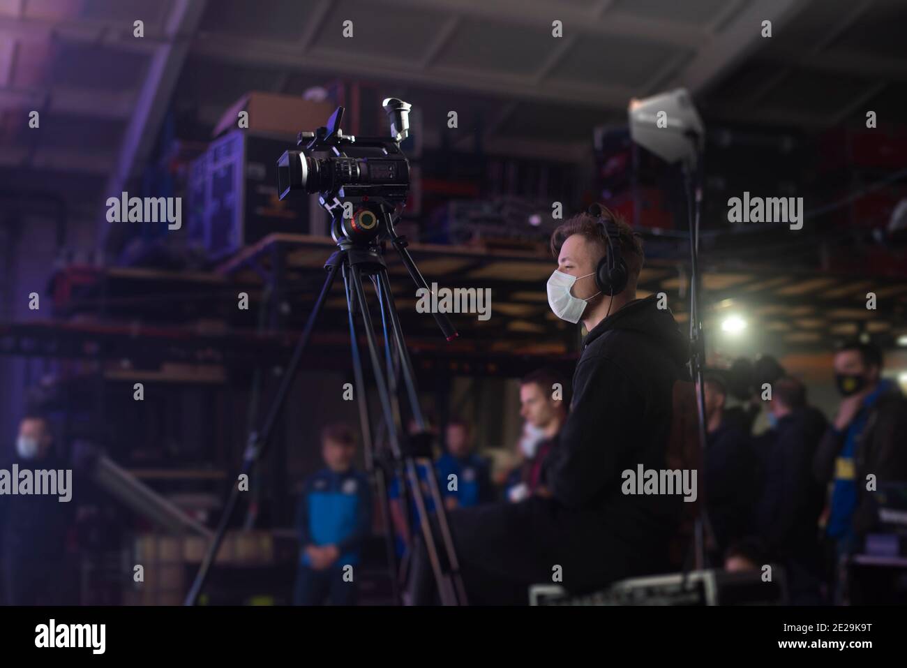 masked cameraman is filming a television show in the studio. TV Stock ...