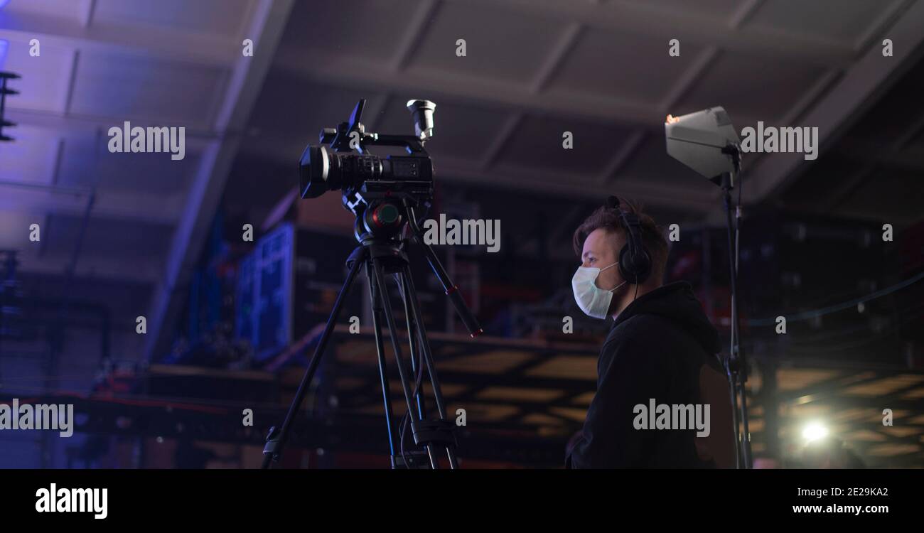 masked cameraman is filming a television show in the studio. TV Stock ...