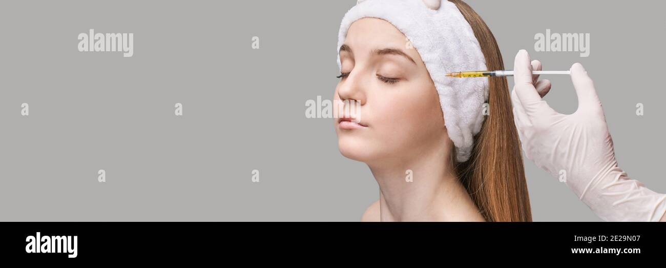 Cheek injection at spa salon. Doctor hands. Pretty female patient ...