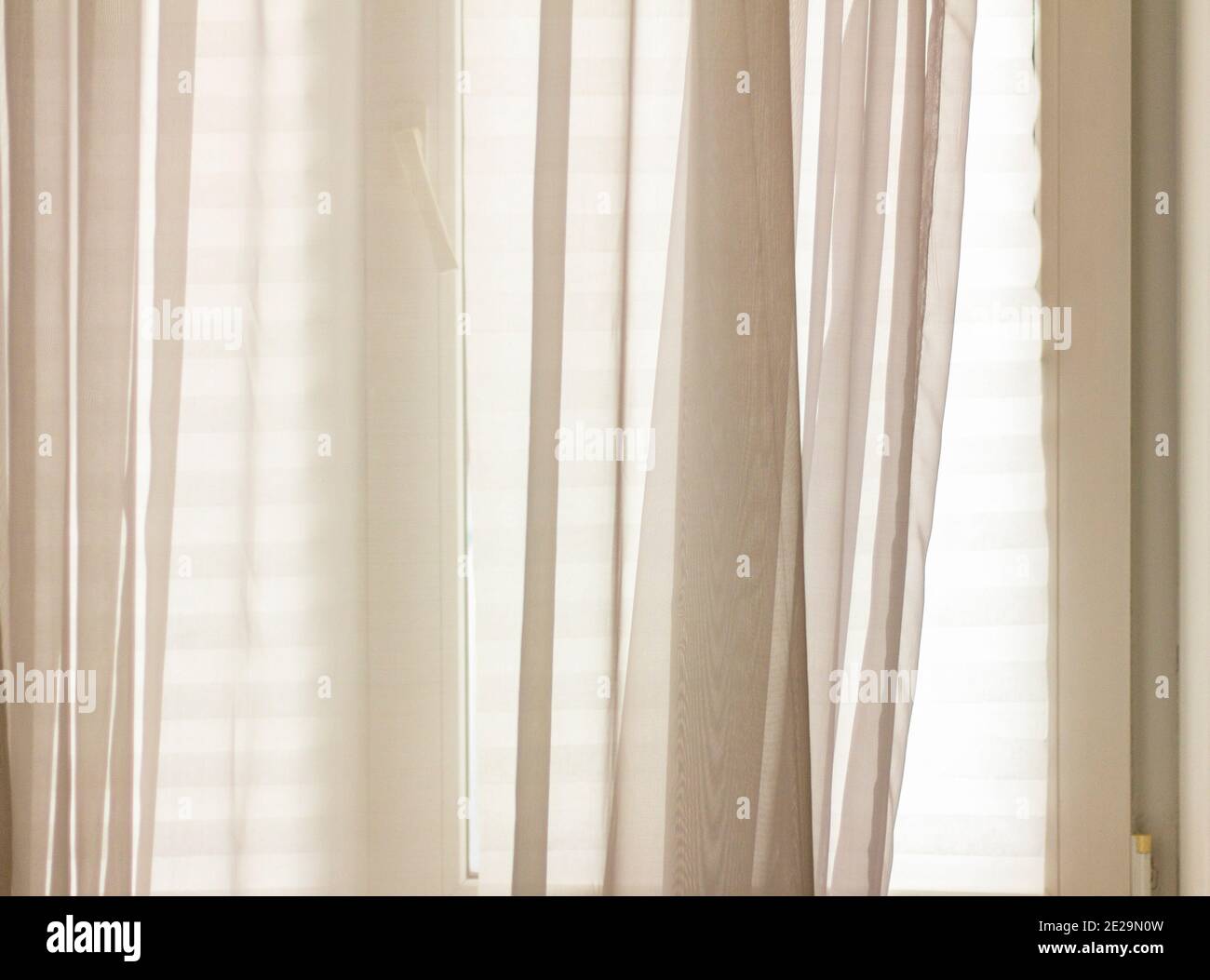 A window in a room with drawn blinds and a light veil Stock Photo - Alamy