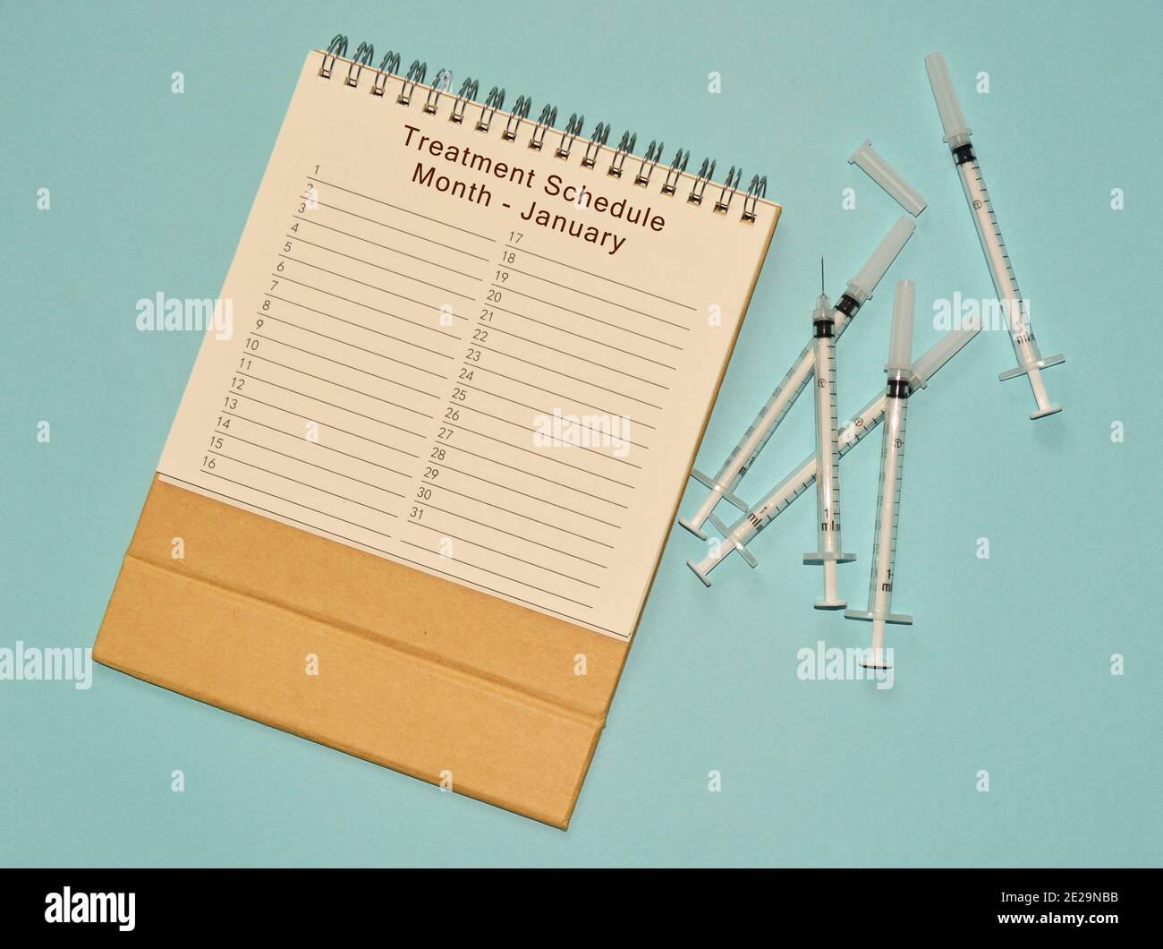 January treatment schedule calendar and disposable injection syringe on ...