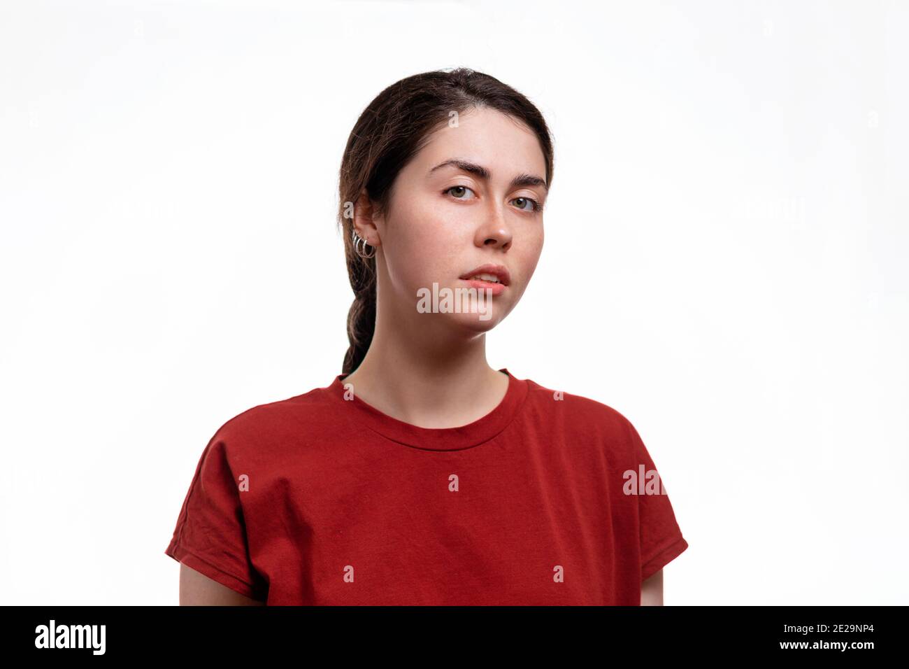 Portrait of a young woman with a disgruntled face. White background ...