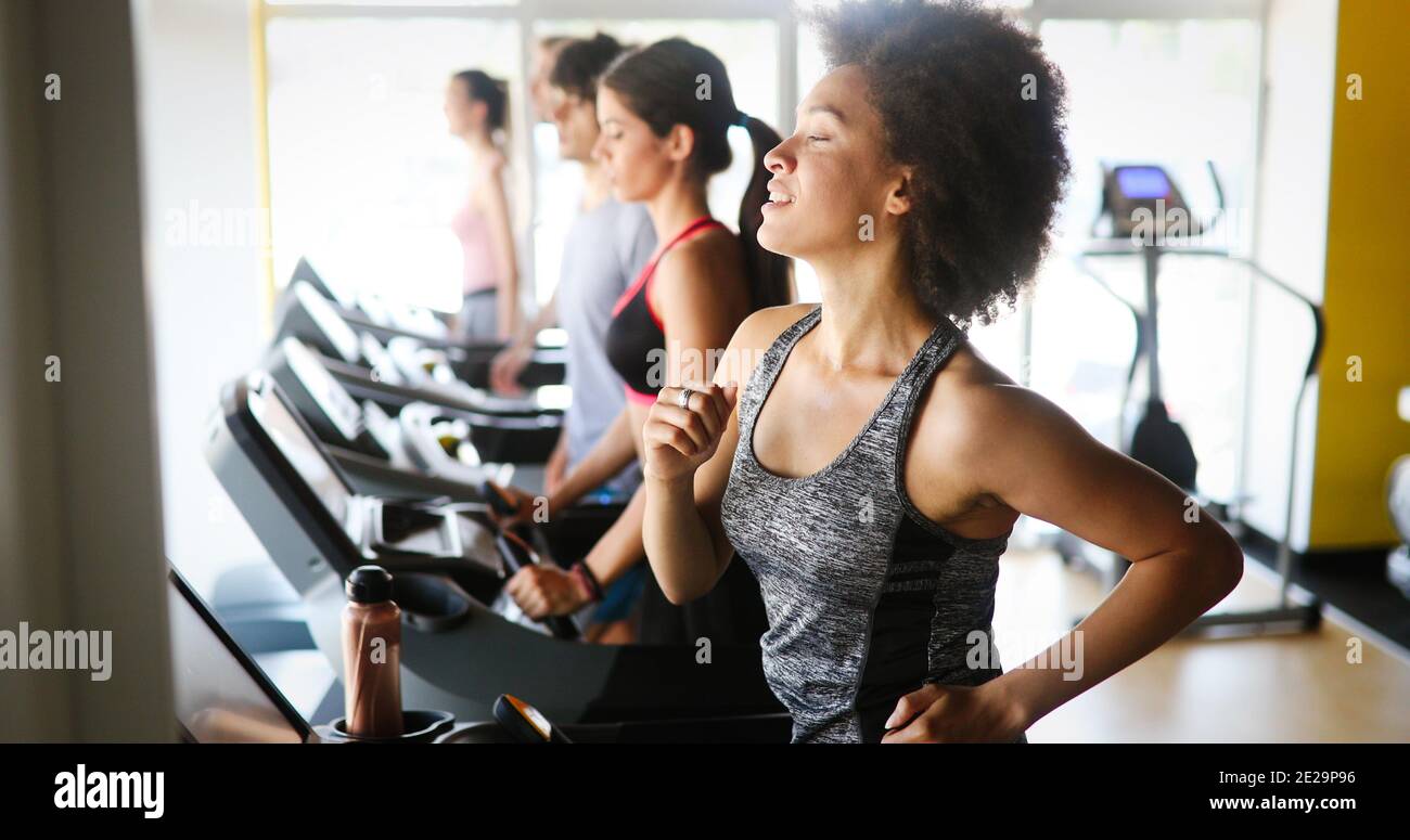 Young people running on a treadmill in health club Stock Photo - Alamy