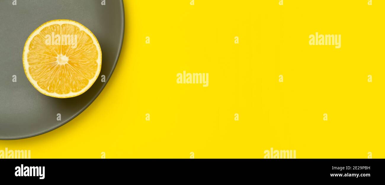 Illuminating yellow lemon on a ultimate gray plate on a bright yellow ...