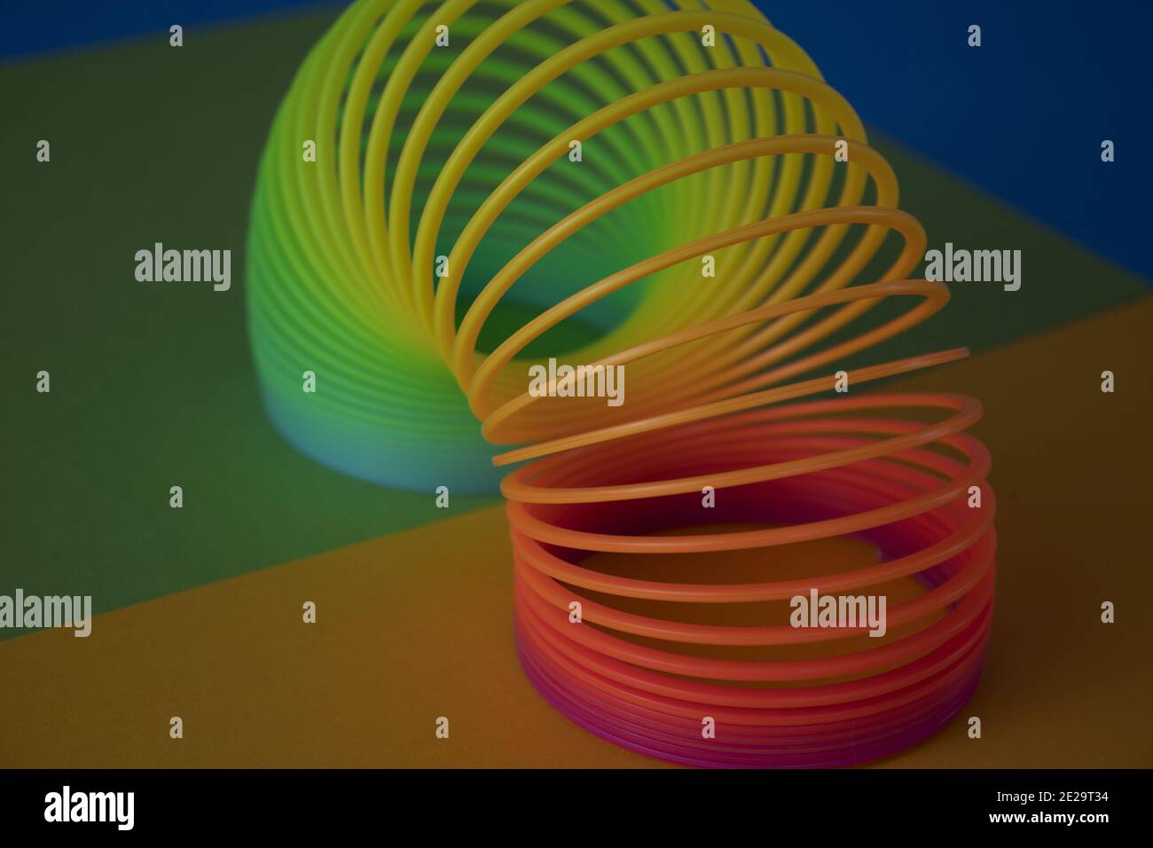 Closeup shot of plastic rainbow magic spring toy against colorful ...