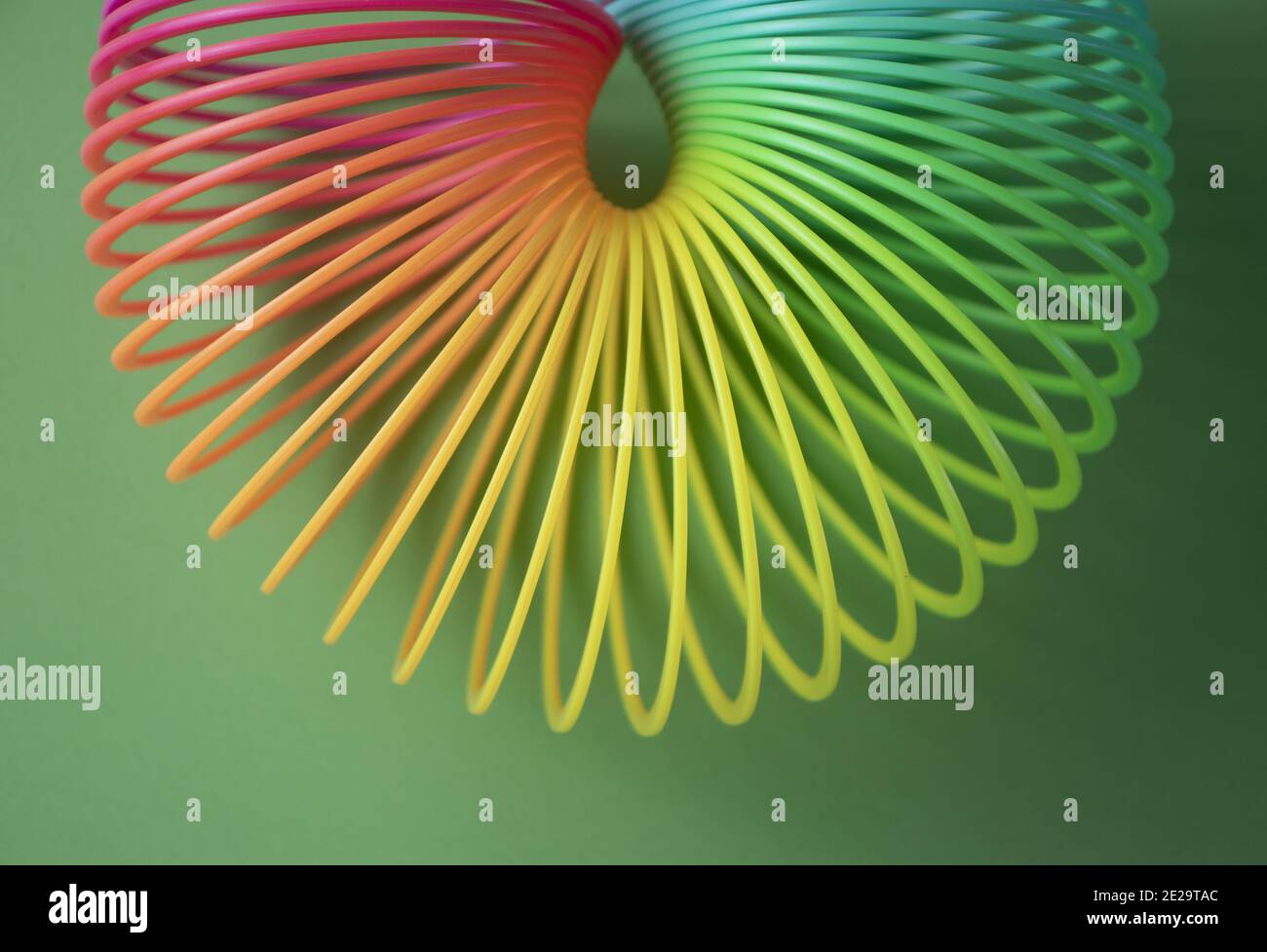 Top view of plastic rainbow magic spring toy isolated on green ...