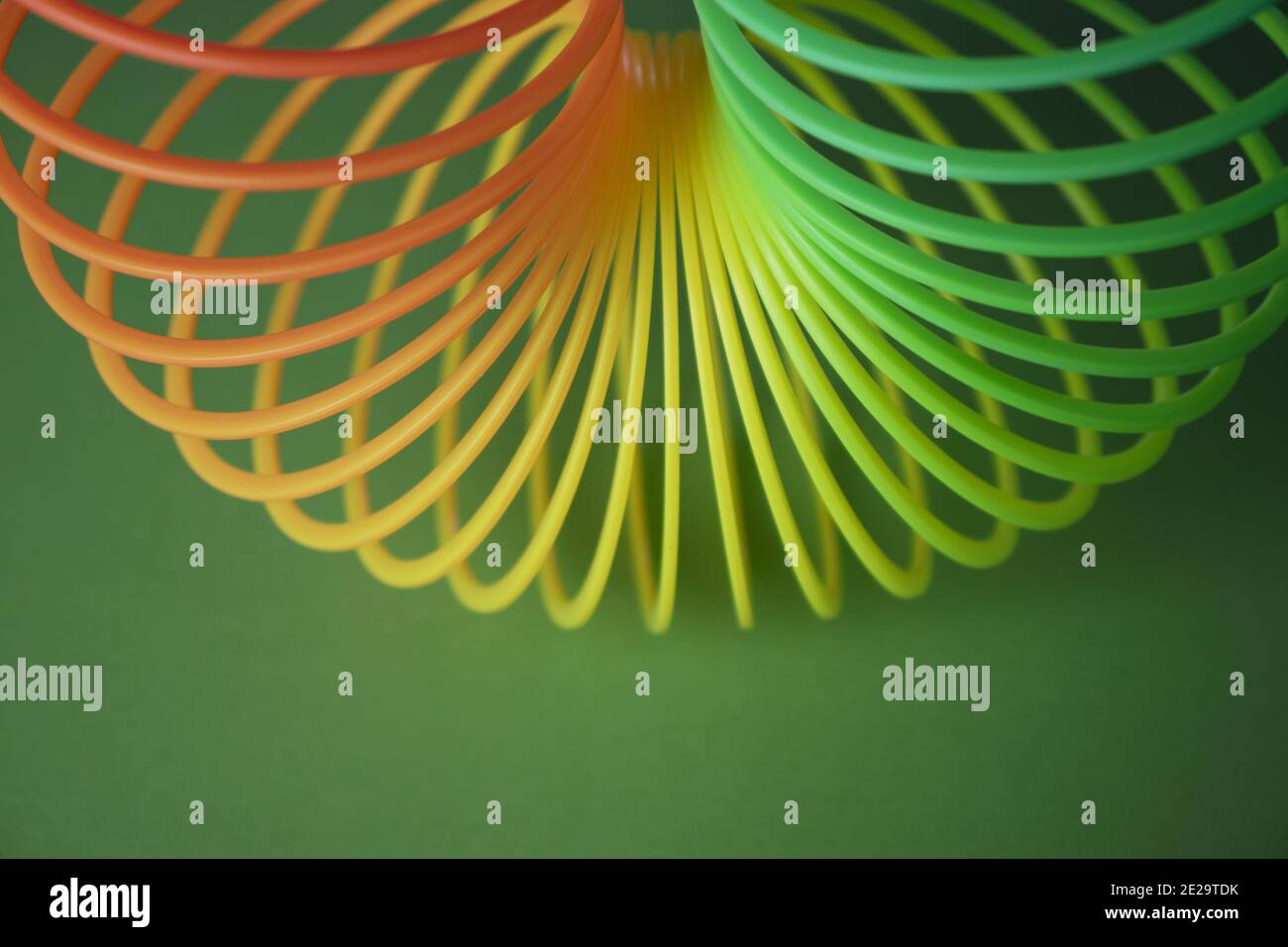 Top view of plastic rainbow magic spring toy isolated on green ...