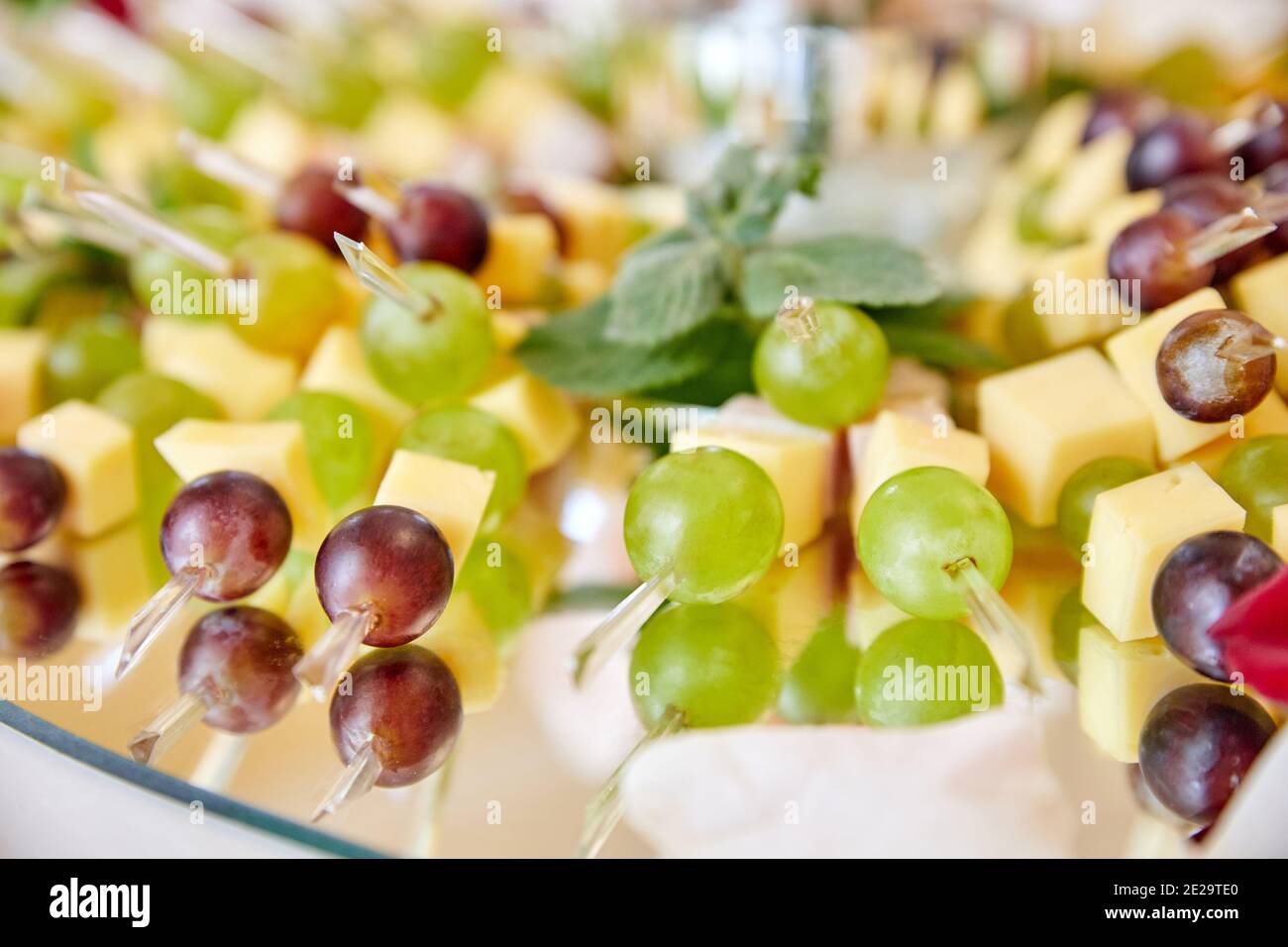 Smorgasbord. Canapes with cheese, bacon, green and red grapes on the ...