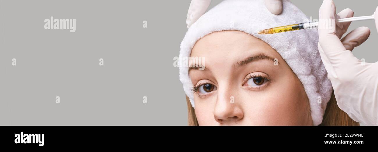 Forehead injection at spa salon. Doctor hands. Pretty female patient ...