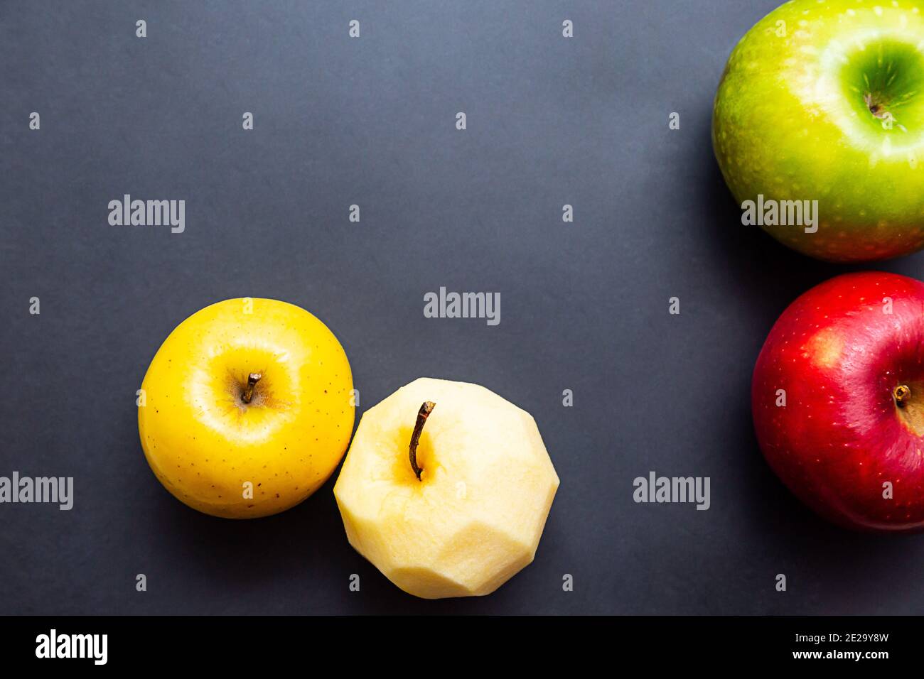Apples green, yellow, red and apple without peel on a black background ...