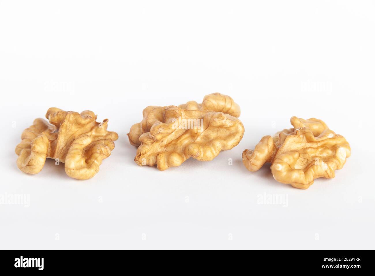Three walnut halves in a line Stock Photo - Alamy