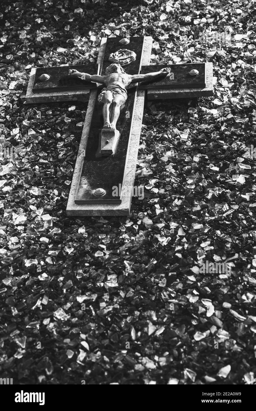 Crucifix on tomb covered with shiny glass shards. Typical burial memorial tradition at ...