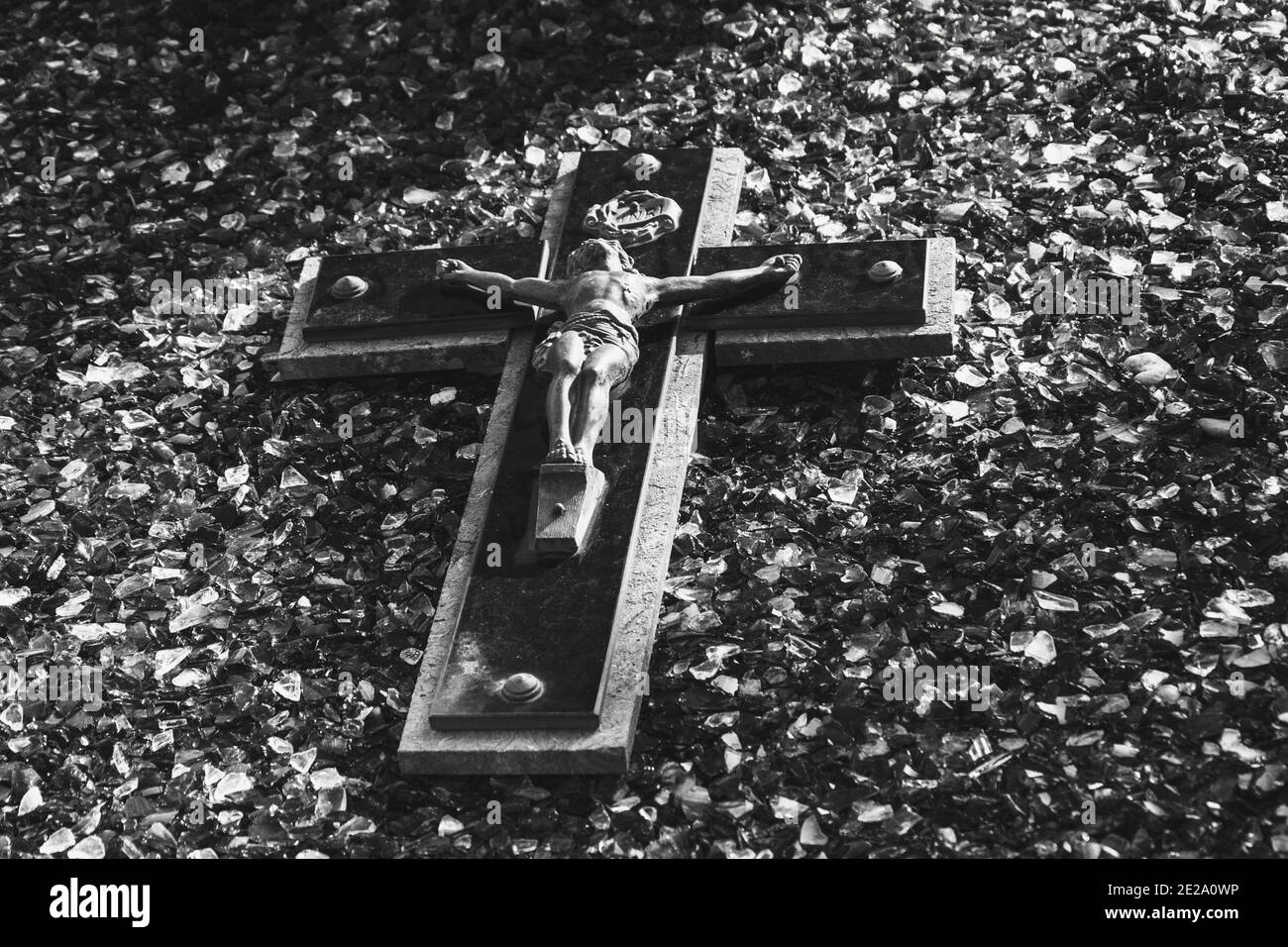Crucifix on tomb covered with shiny glass shards. Typical burial memorial tradition at ...
