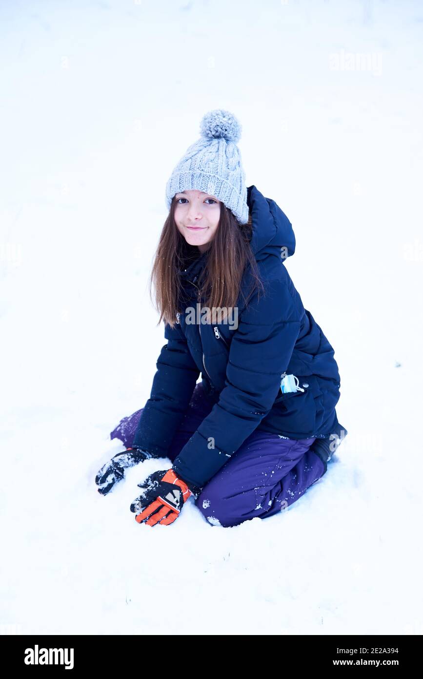 Teenage girl in a sport winter outfit playing in the snow Stock Photo ...