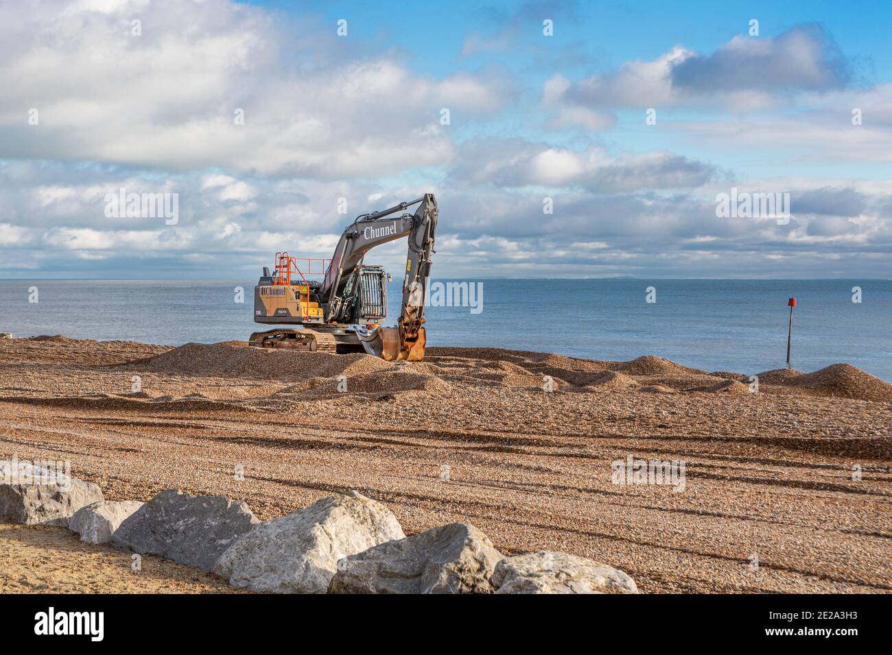 A digger preparing flood defenses on Hythe beach, Kent Stock Photo - Alamy