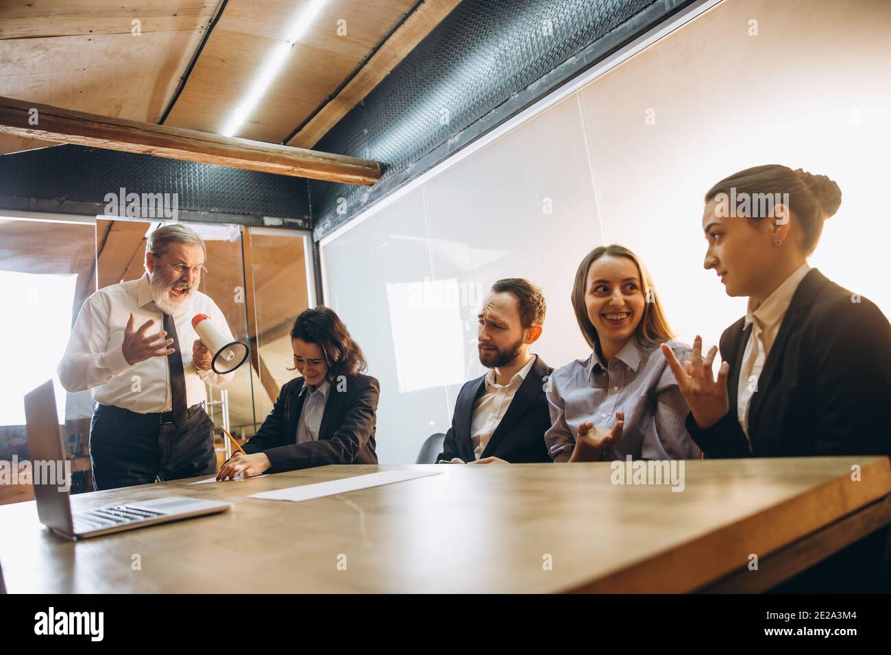 Anger. Angry boss with megaphone screaming at employees in office ...