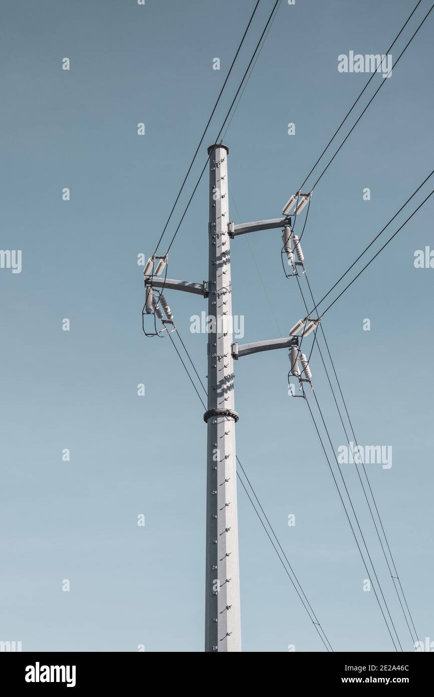 Vertical shot of electric lines under bl Stock Photo - Alamy