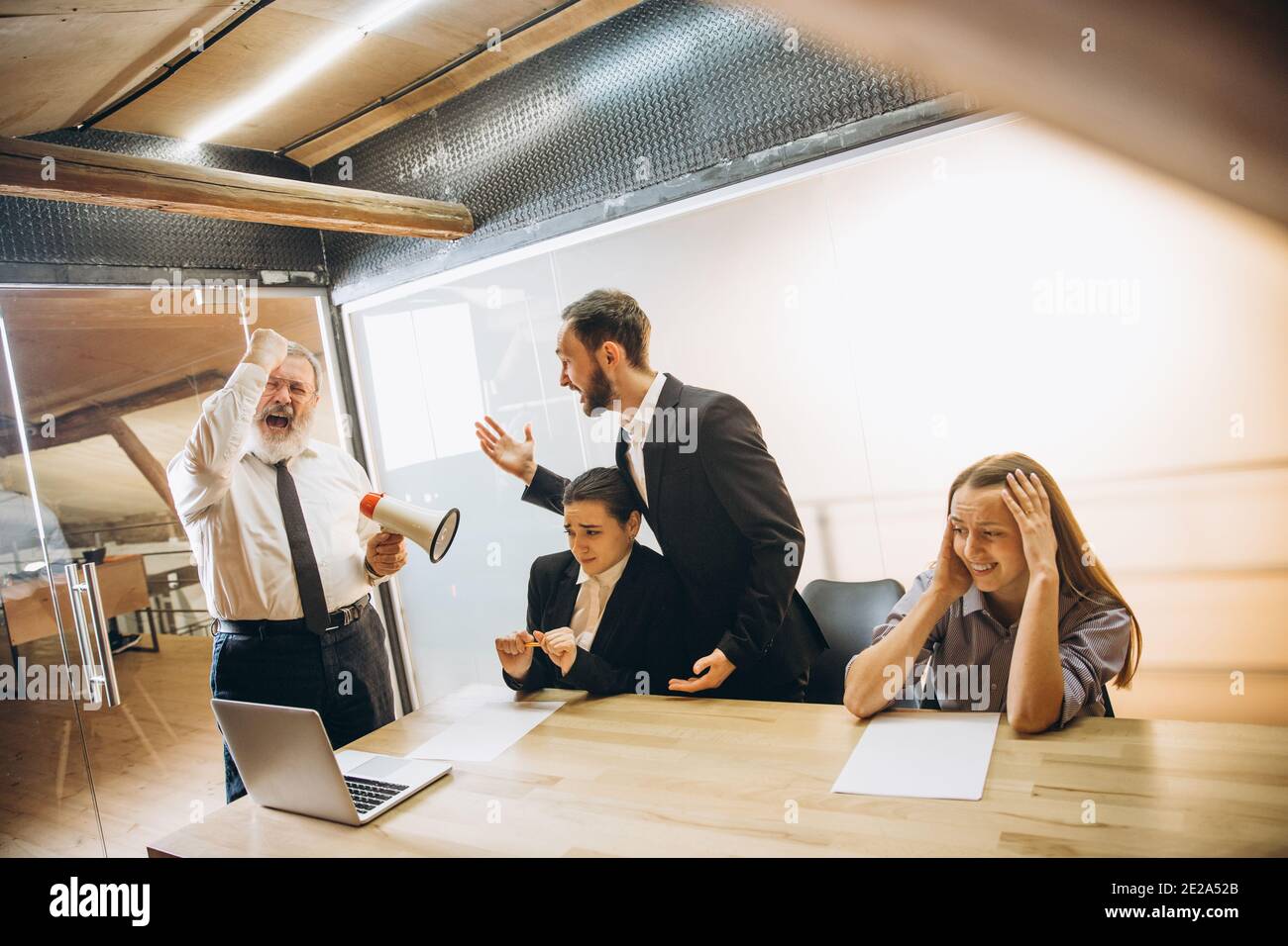 Argument. Angry boss with megaphone screaming at employees in office ...